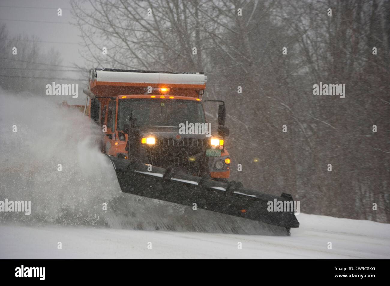 heavy duty snowplow clearing a rural road during a winter blizzard in ...