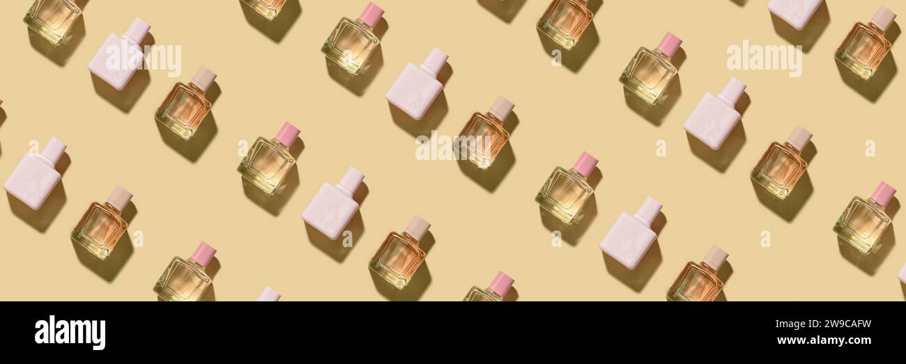 Many bottles of different perfumes on beige background. Pattern for ...