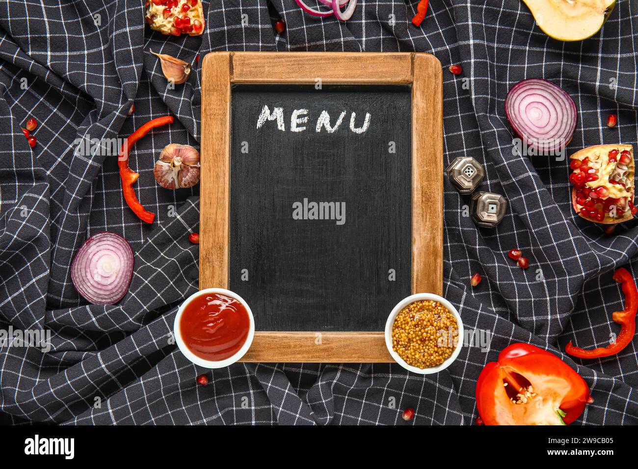 Composition with blank menu board, sauces and spices on dark fabric ...