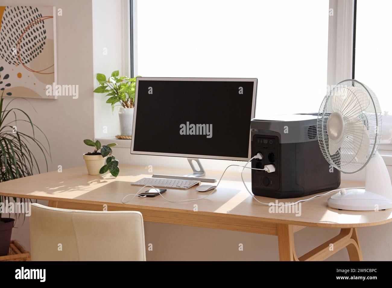 Comfortable workspace with modern computer and portable power station ...