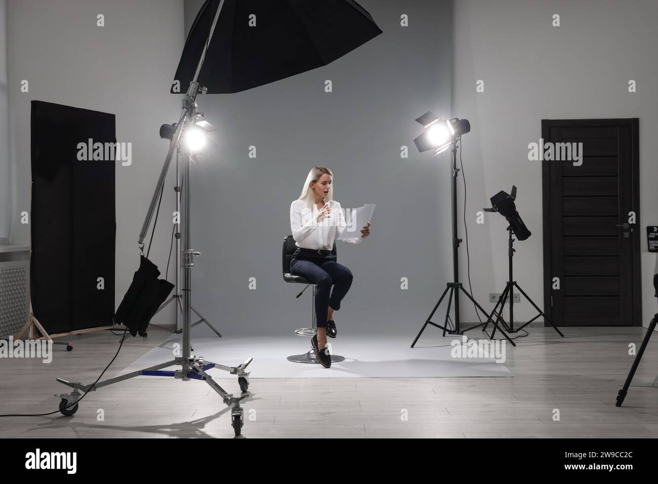 Casting call. Emotional woman with script performing against grey ...