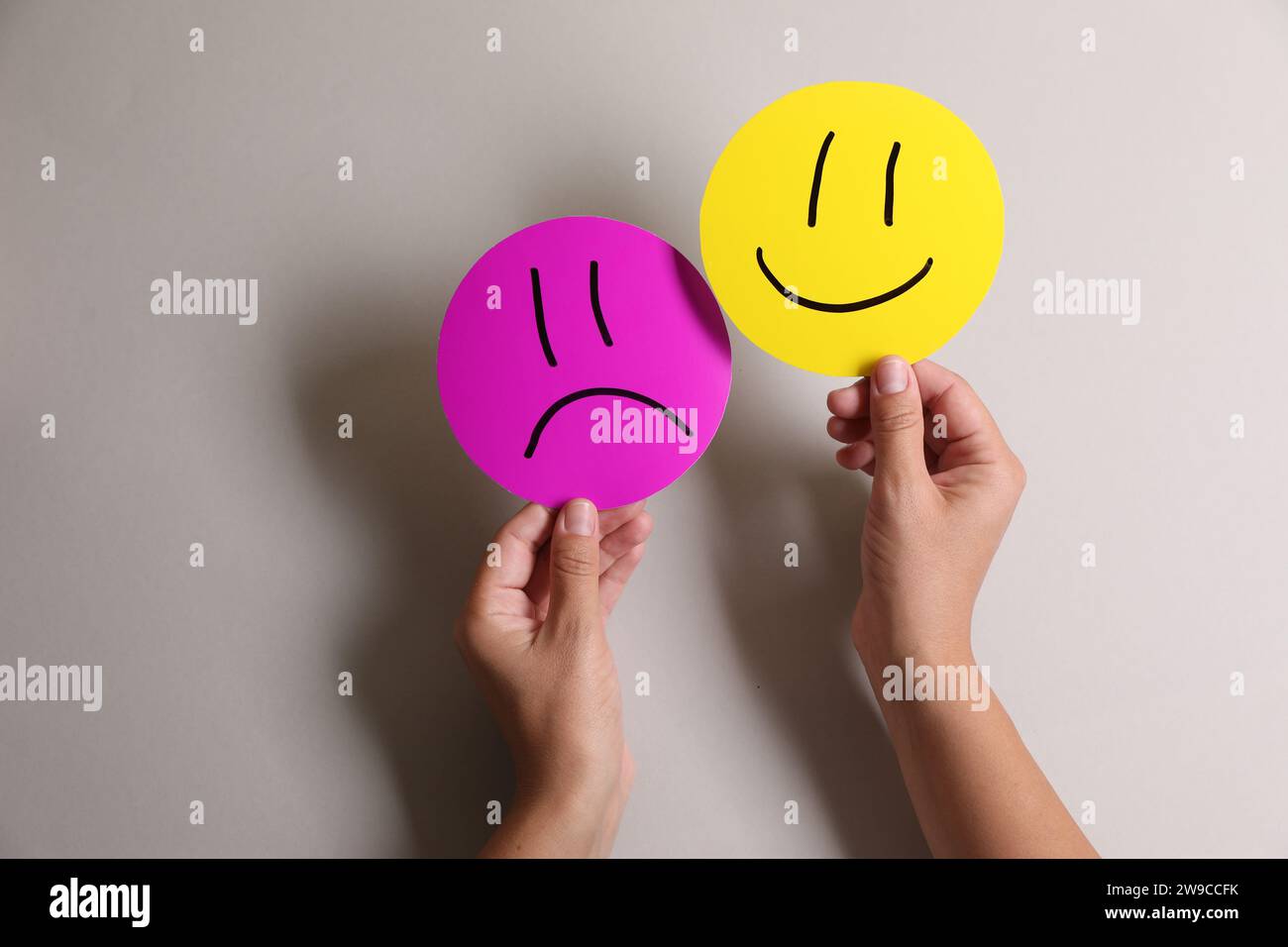 Choice concept. Woman holding papers with sad and happy emoticons on ...