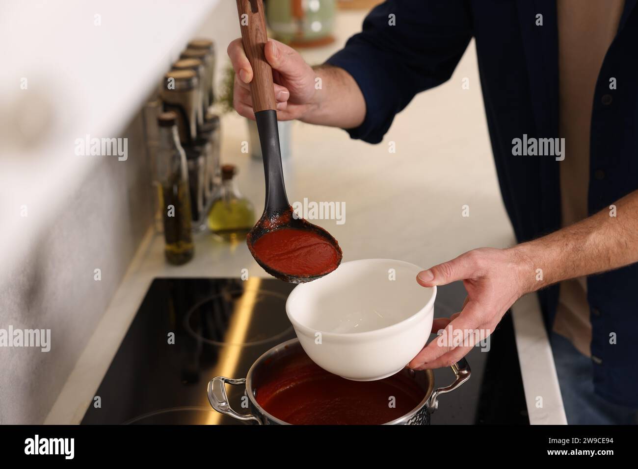Man pouring delicious tomato soup into bowl in kitchen, closeup Stock ...