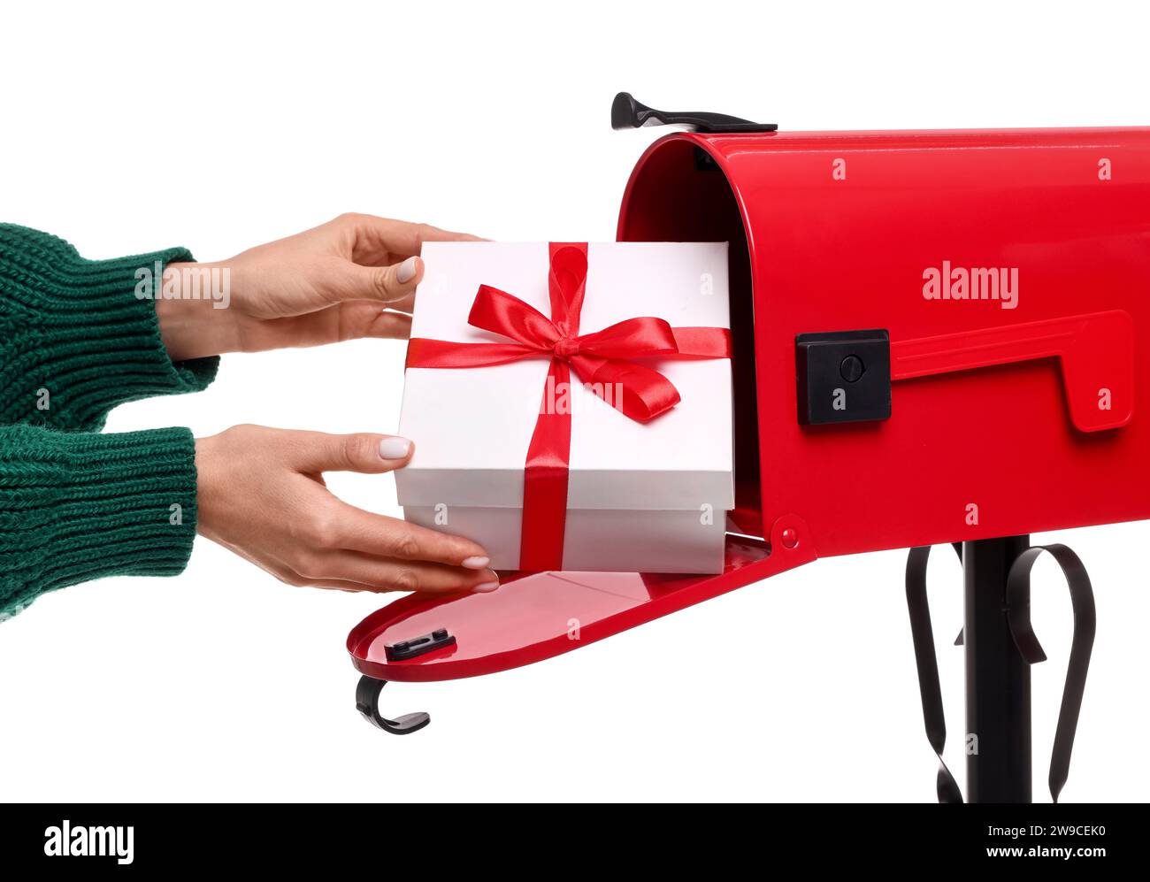 Woman putting Christmas gift into mailbox on white background, closeup ...