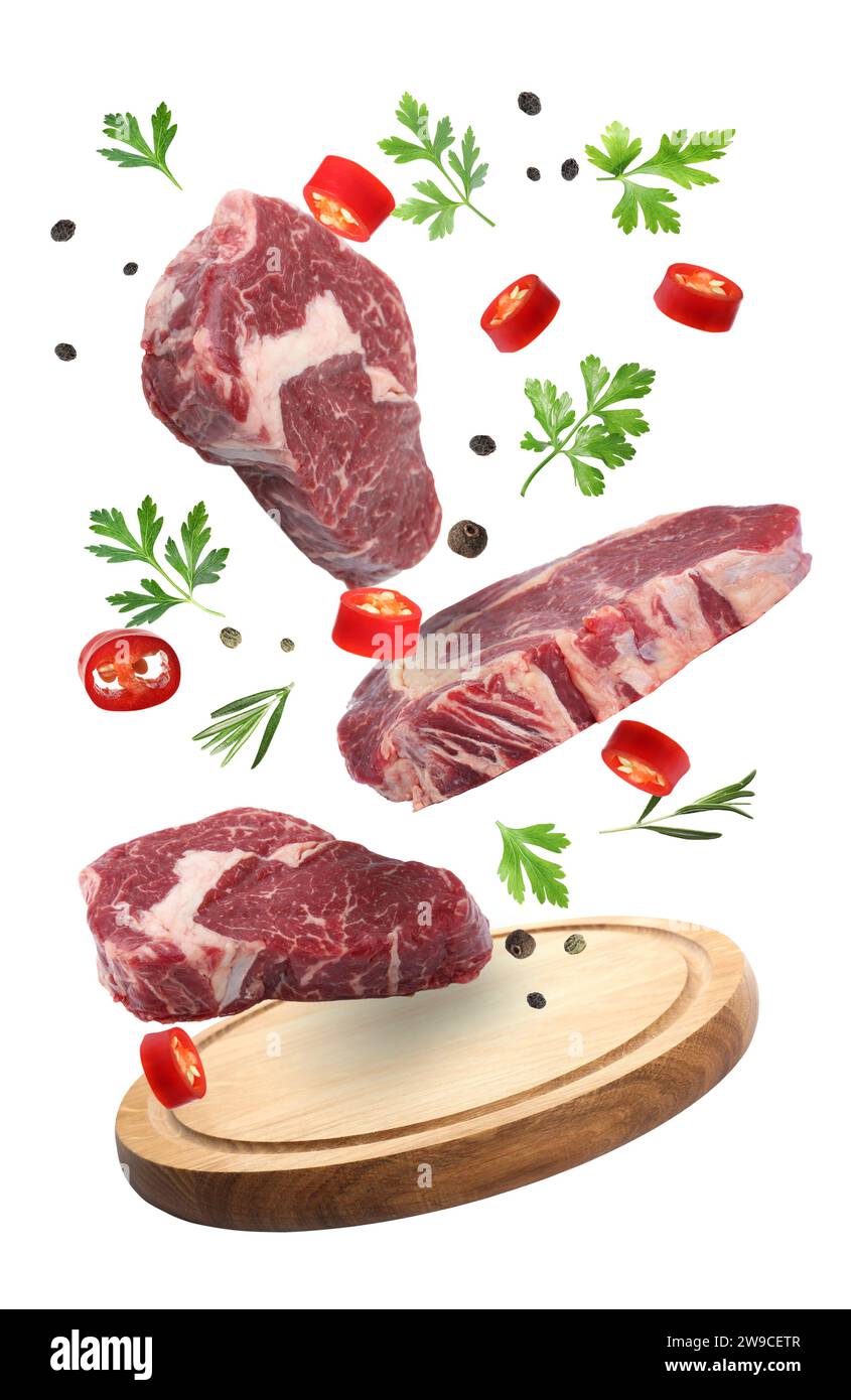 Beef meat, different spices and board falling on white background Stock ...