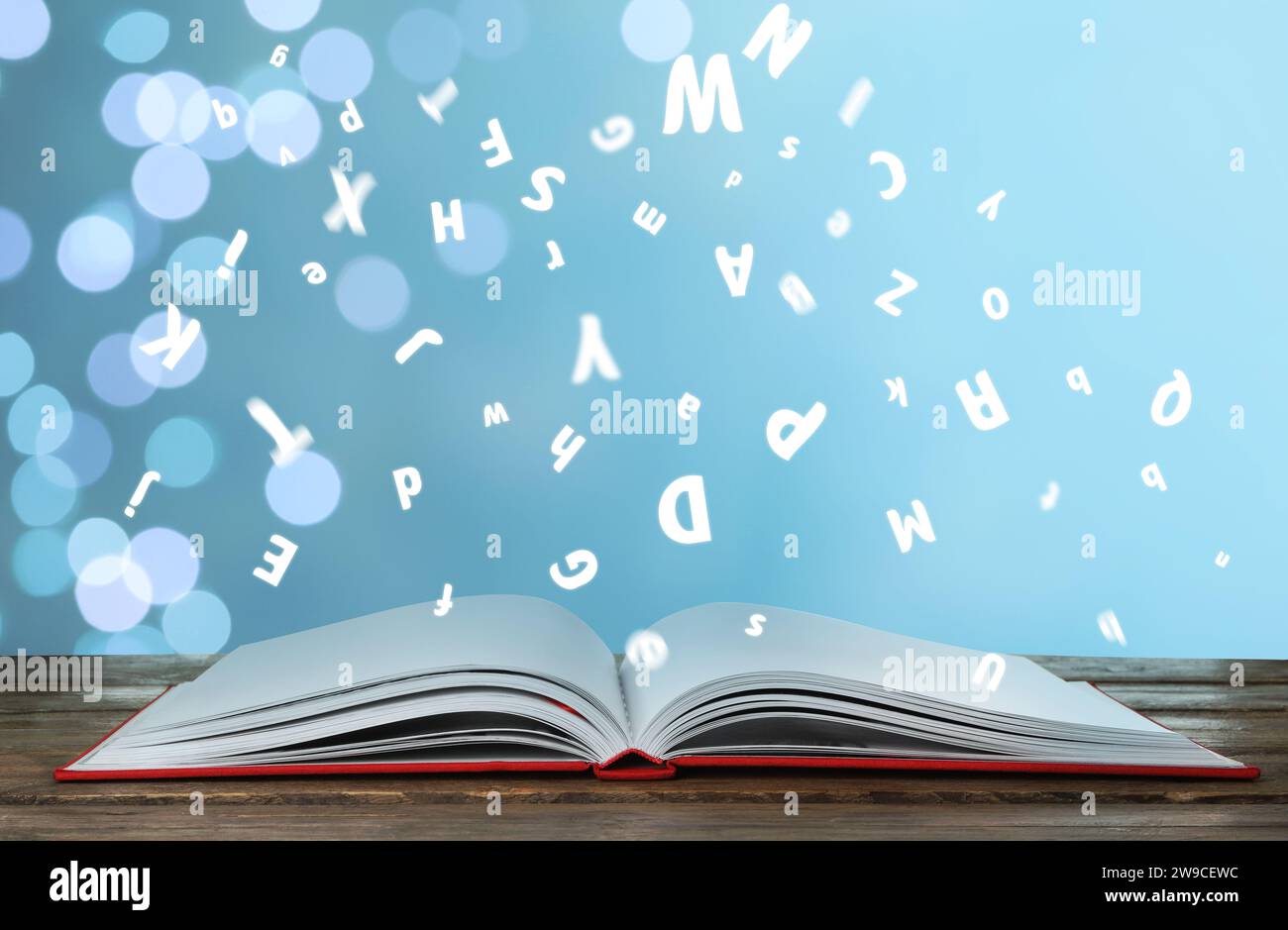 Letters flying out from open book on wooden table, bokeh effect Stock Photo - Alamy