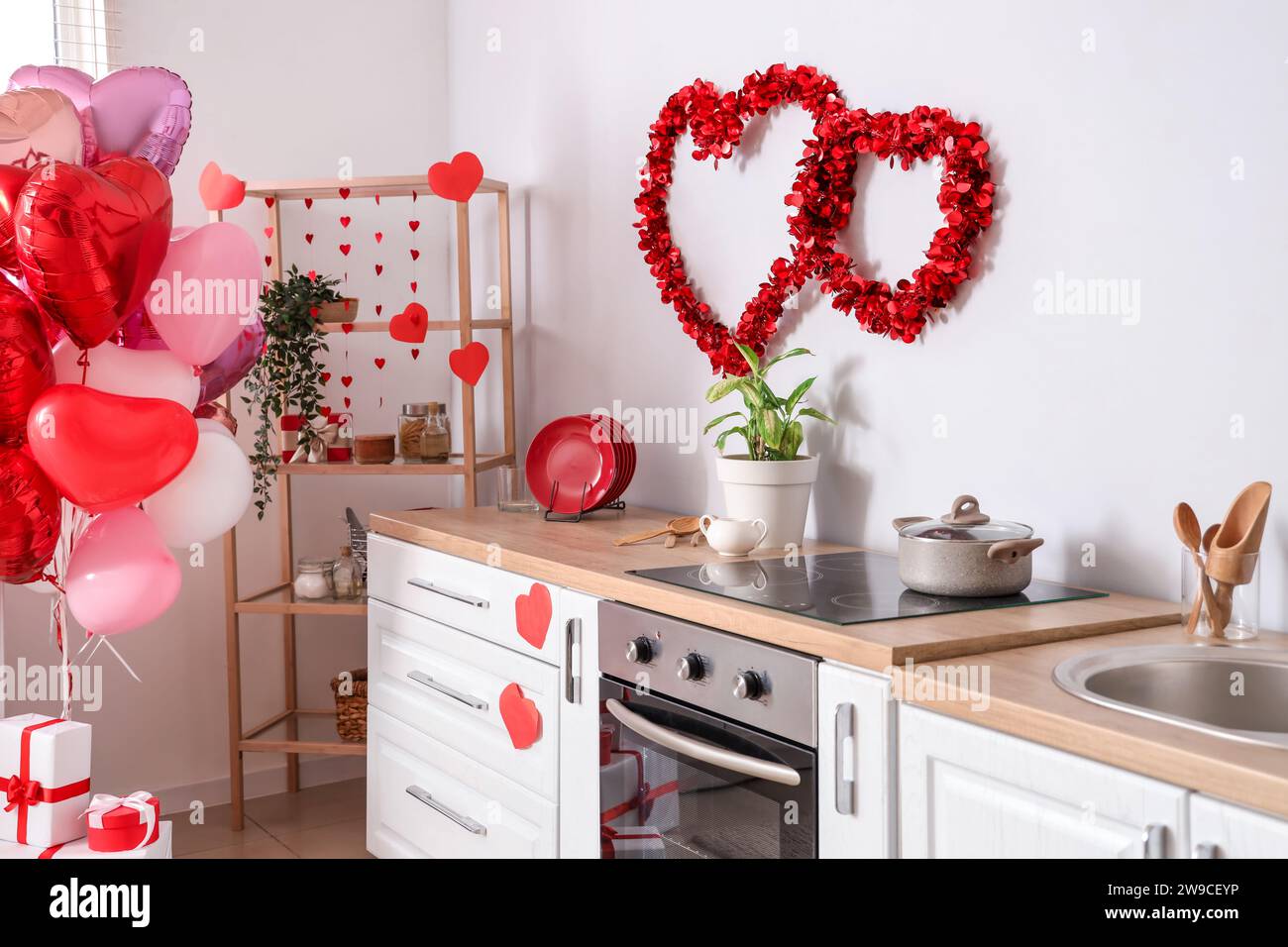 Interior of light kitchen with heart-shaped balloons, gift boxes and ...