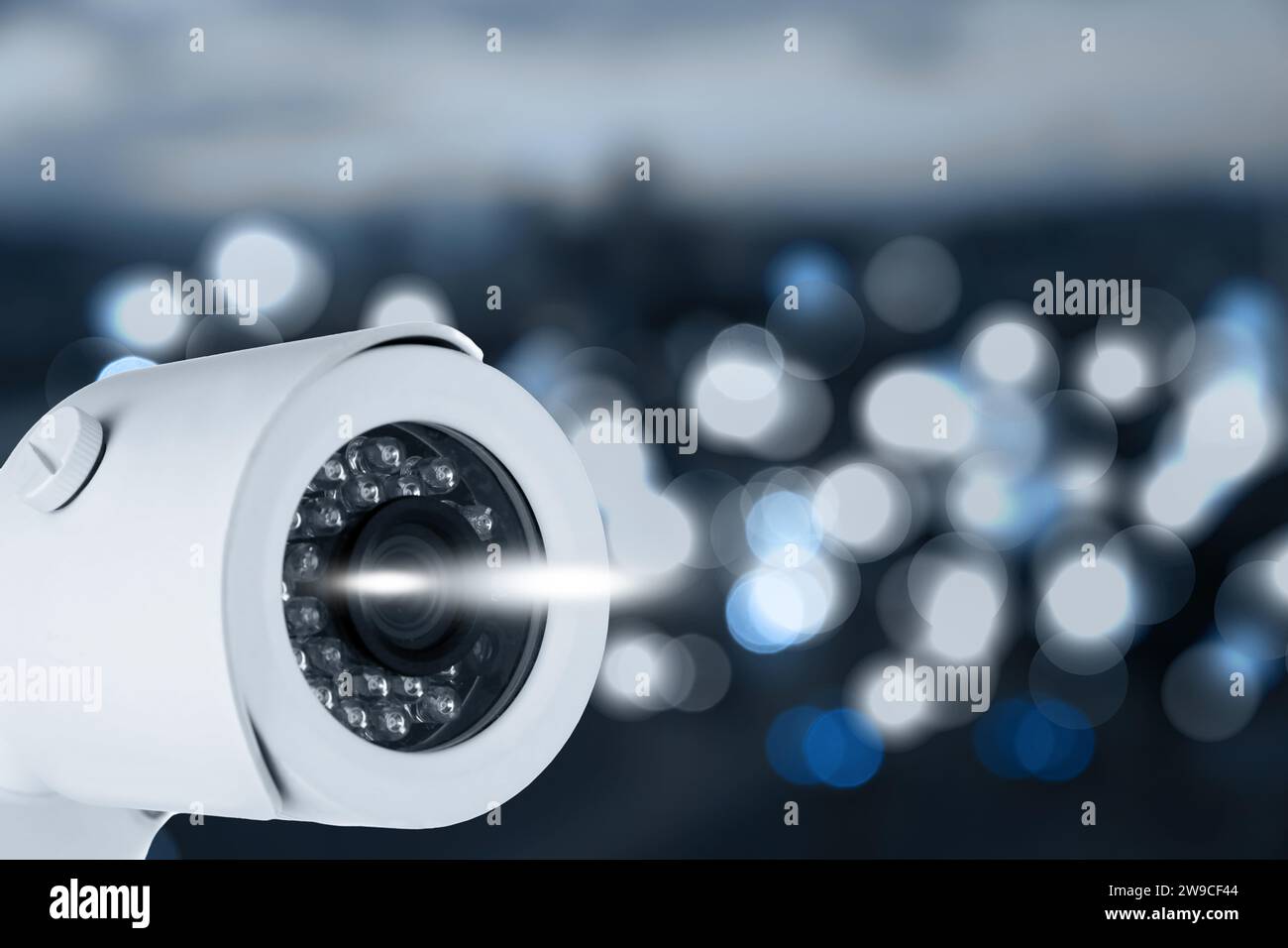 Modern security CCTV camera against blurred background, space for text ...