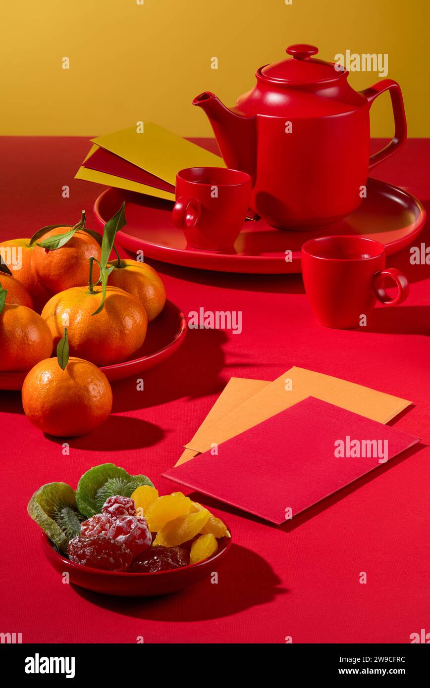 On a red background, a close-up captures a Tet tea set, tangerines ...