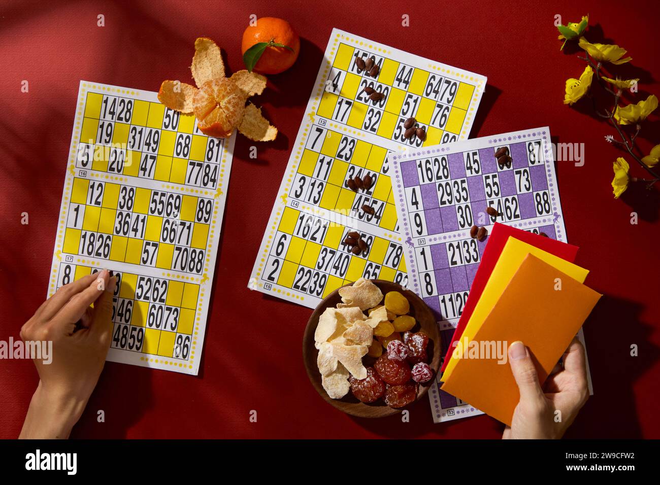 The lotto sheets are displayed on a red background with tangerines and ...