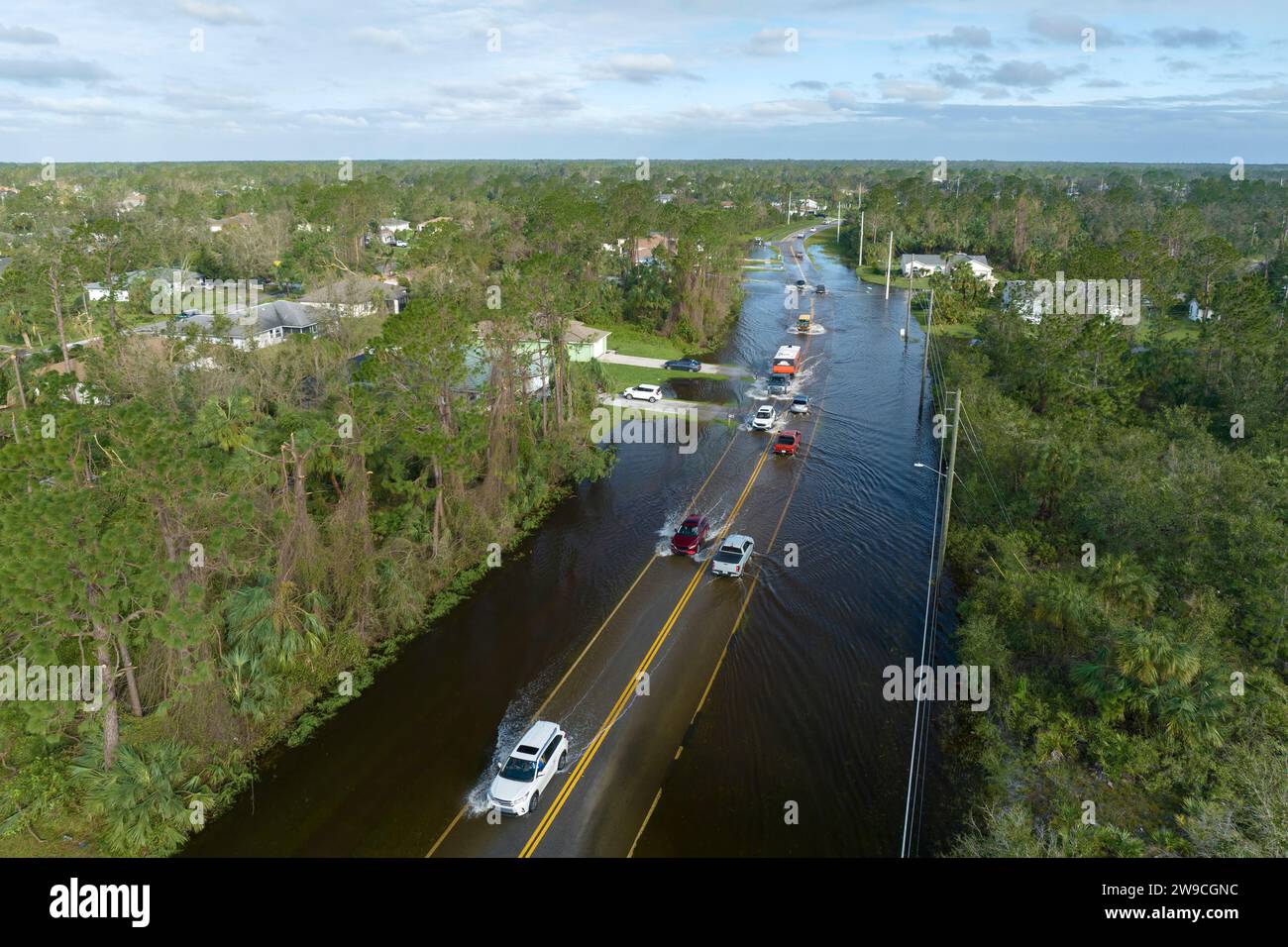 Flooded Florida road with evacuating cars and surrounded with water ...