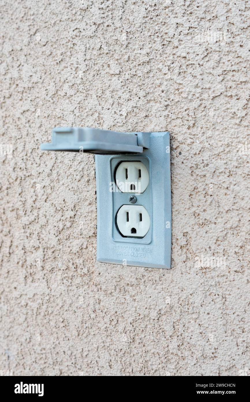 Outdoor electrical outlet with cover in beige stucco wall Stock Photo ...