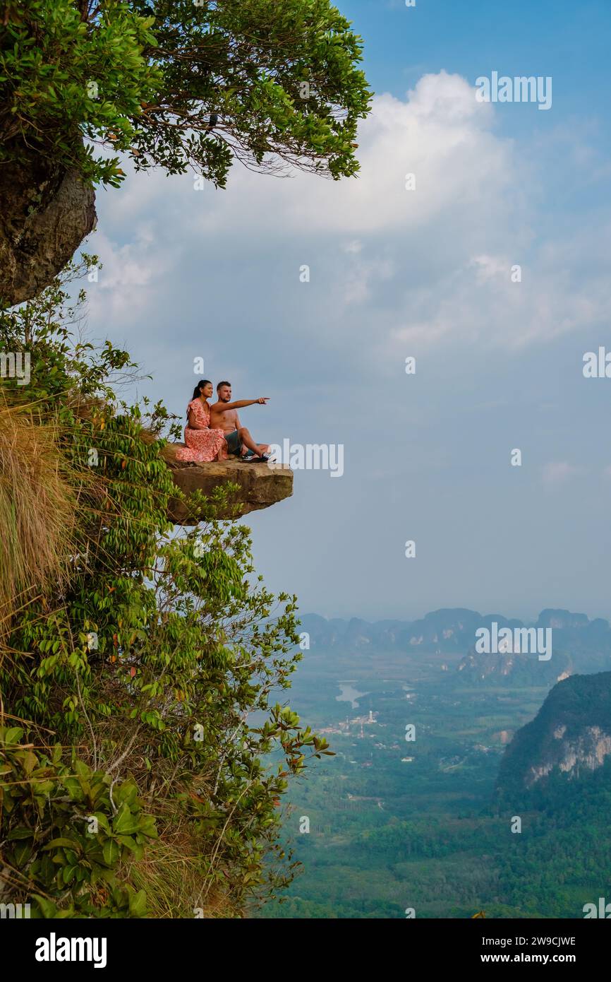 Couple at the edge of a mountain, Dragon Crest Mountain Krabi Thailand, Young travelers sit on a ...