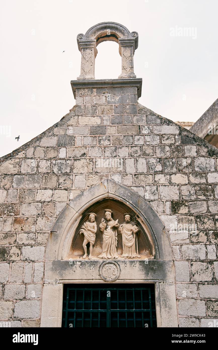 Facade of the church of St. Luke with statues of three saints above the ...