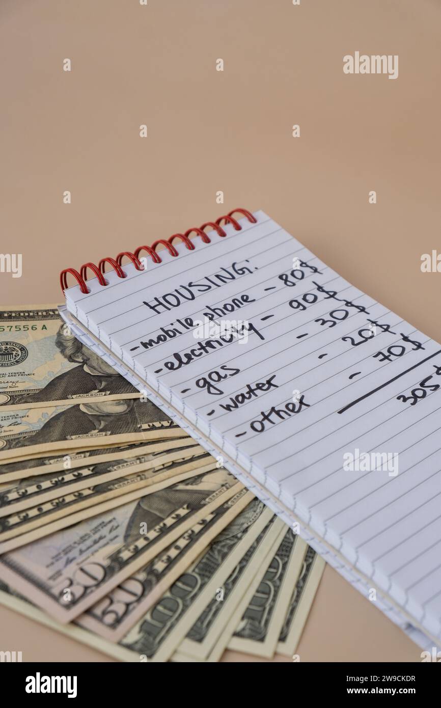 Dollar cash money with notebook handwritten housing expenses. Counting ...