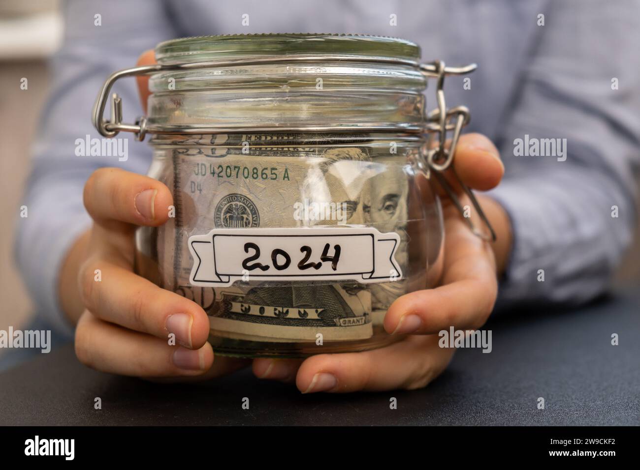 Female hands holding Glass jar full of American currency dollars cash ...