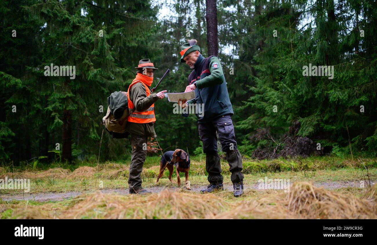 Heimbuch, Germany. 14th Dec, 2023. Two hunters discuss before a driven ...