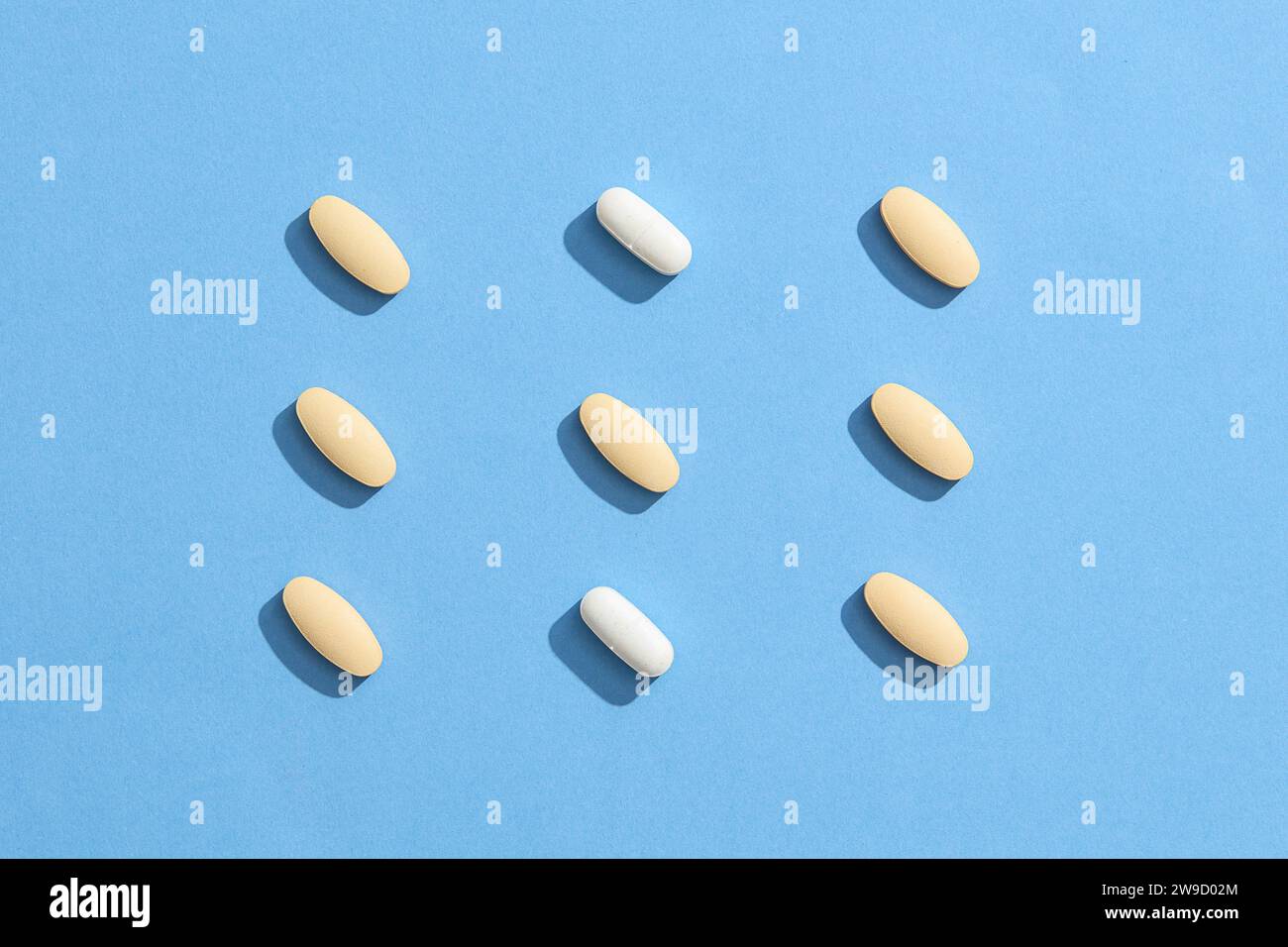 Top view of pills are evenly arranged on a green background, simulating ...