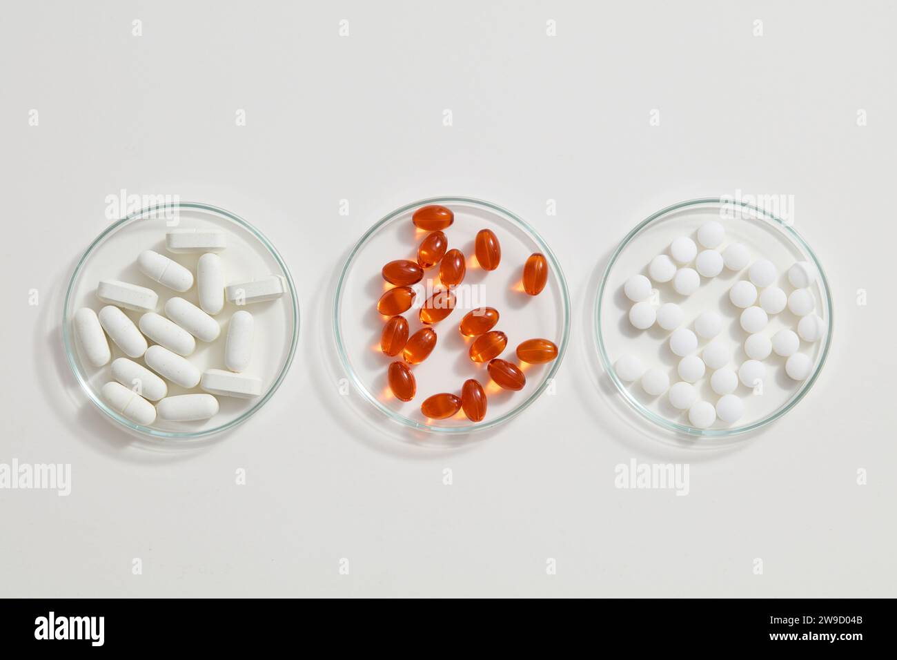 Top view, 3 transparent dishes containing 3 types of pills with ...