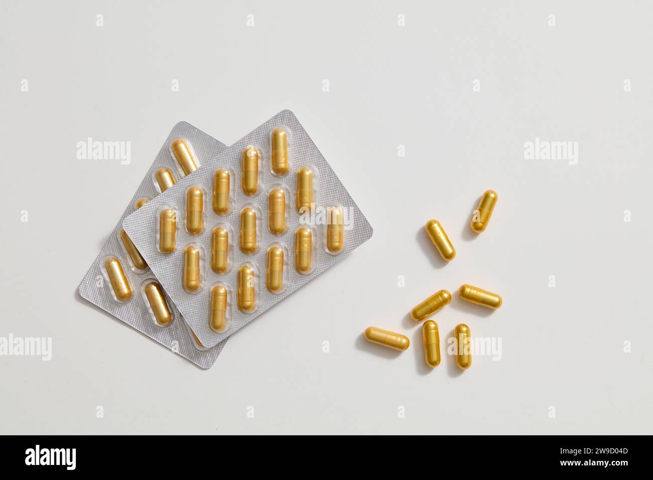 2 blister packs and yellow capsules displayed on a white background ...