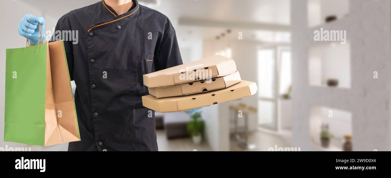 box with fast food being carried by delivery man in uniform for one of ...