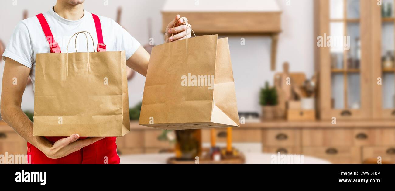 box with fast food being carried by delivery man in uniform for one of ...