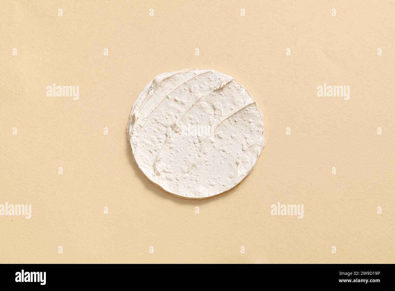 The dense cream texture forms a circle on a pastel-colored background ...