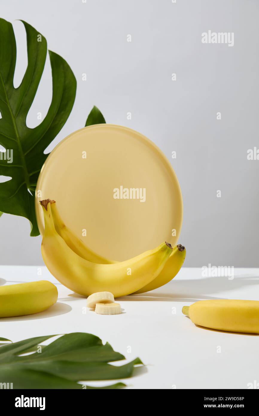 Front view of a yellow disc stood upright with bananas, slices and ...
