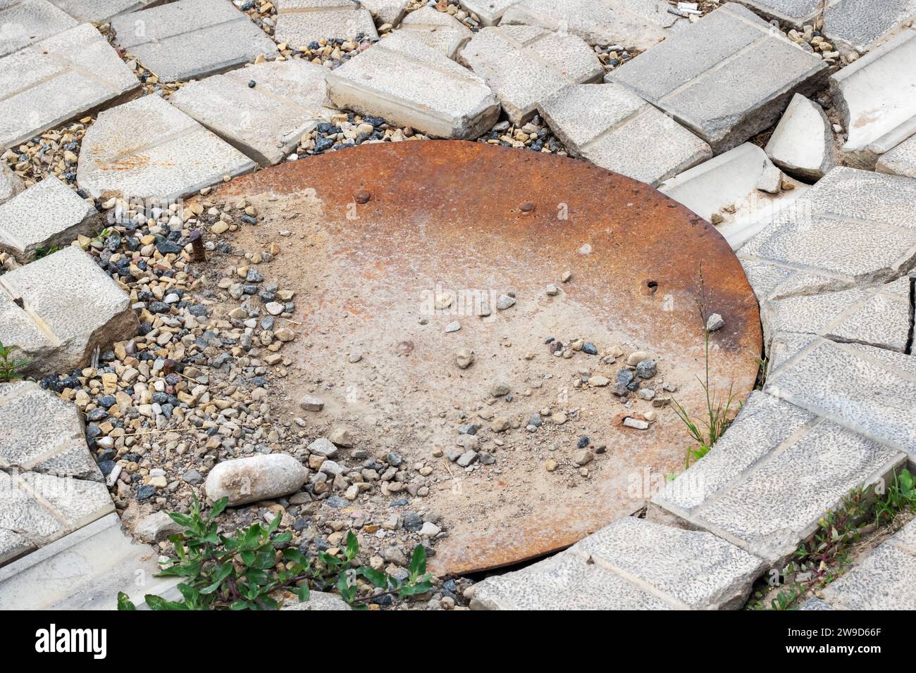 Old rusty manhole in paving slabs close up Stock Photo - Alamy