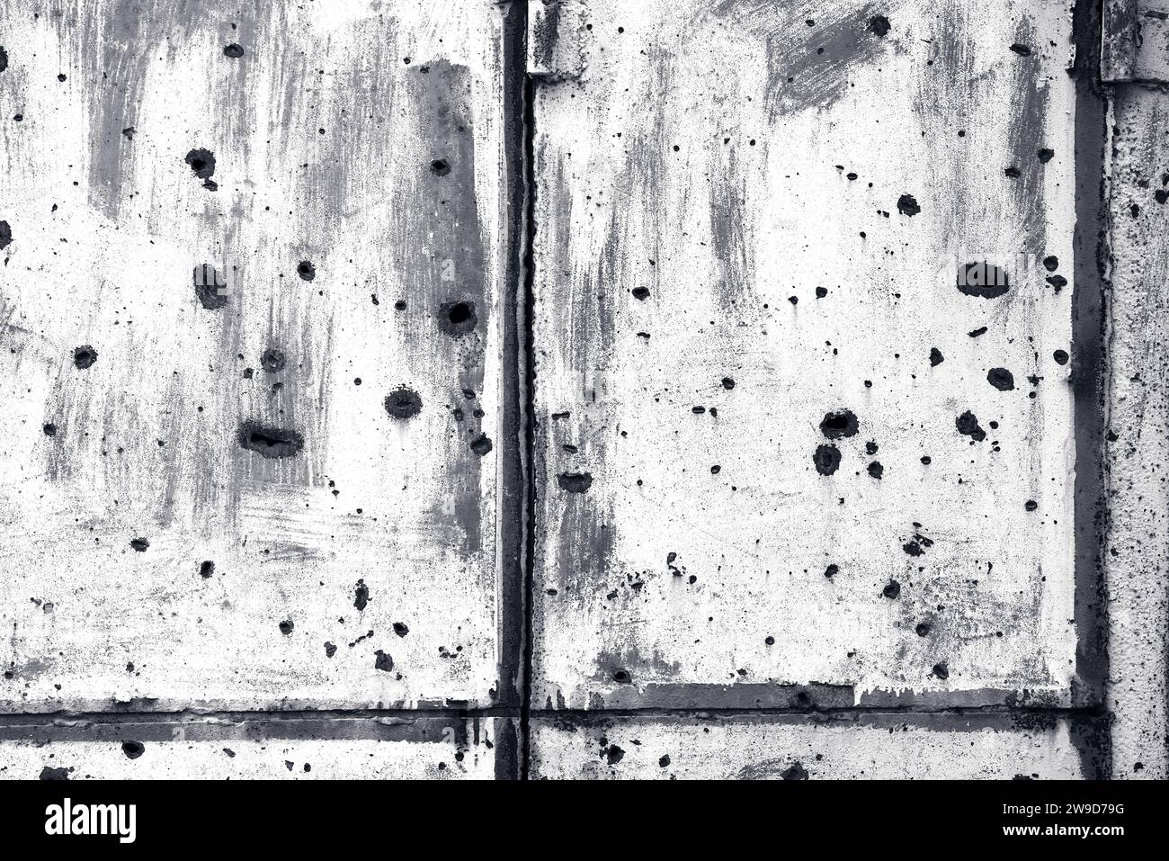 Holes from artillery shell fragments in the wall metal garage. Damage ...