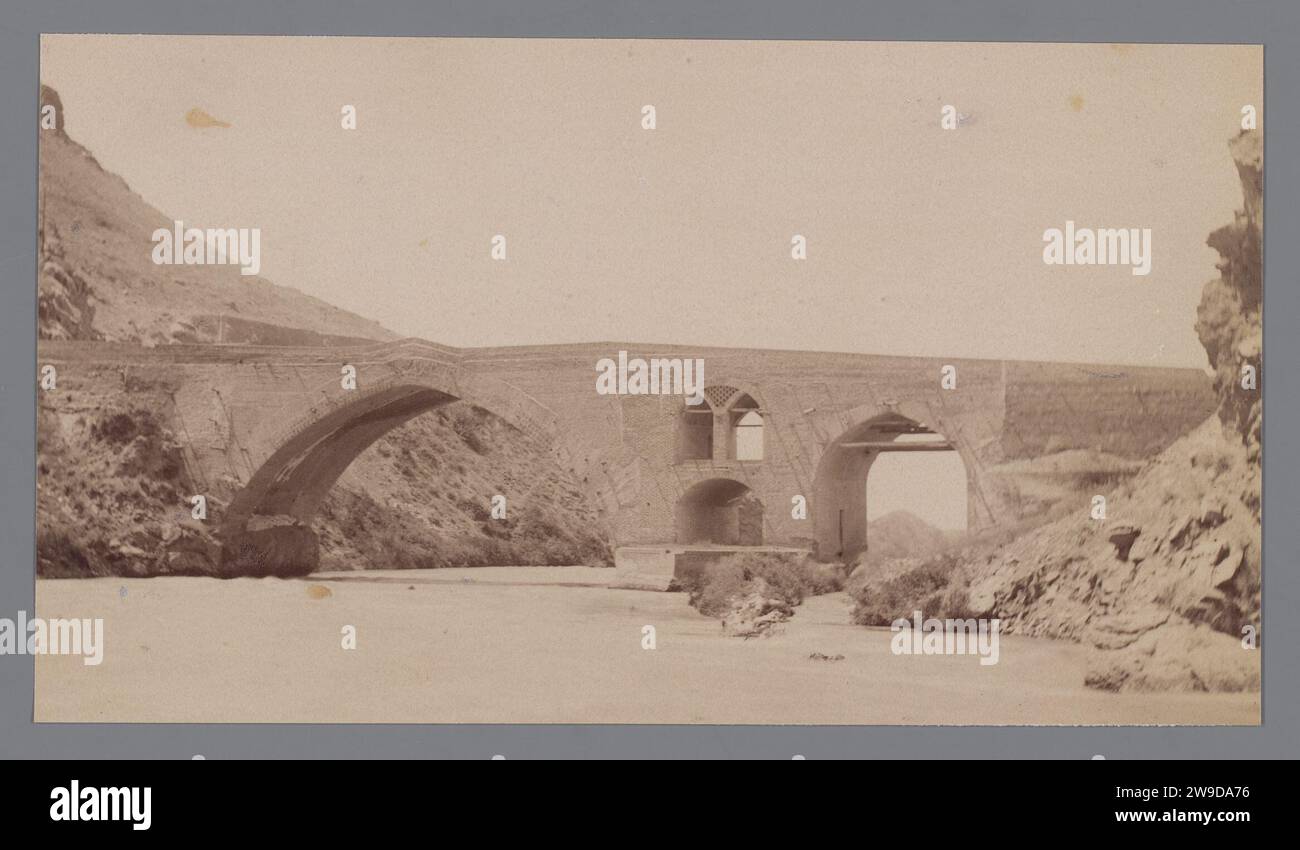 Landscape with river over which a bridge; hills in the background, Iran ...