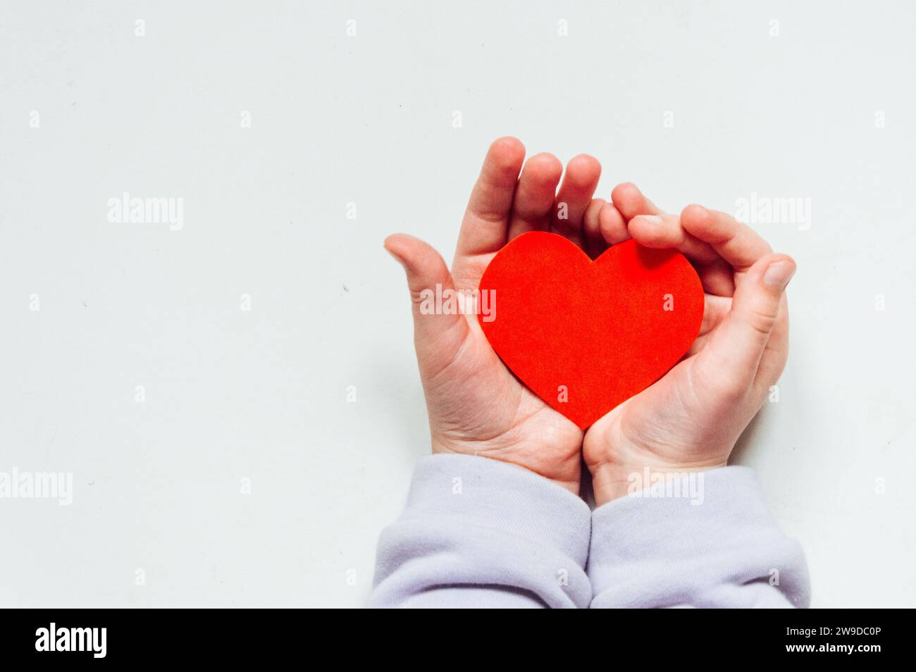 Red heart in children's hands on white background Stock Photo - Alamy