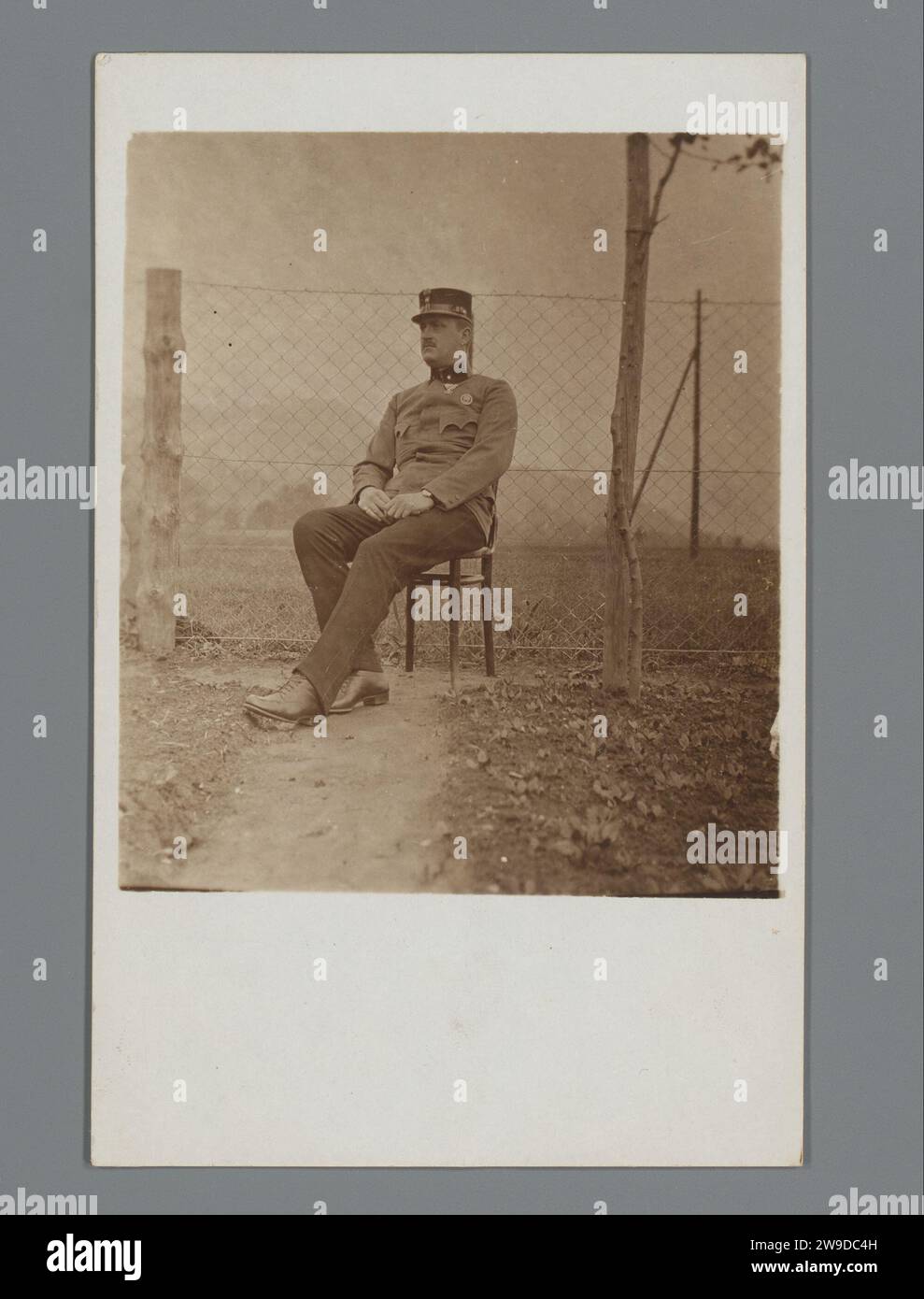 Portrait of an unknown man in uniform outside on a chair, presumably a ...