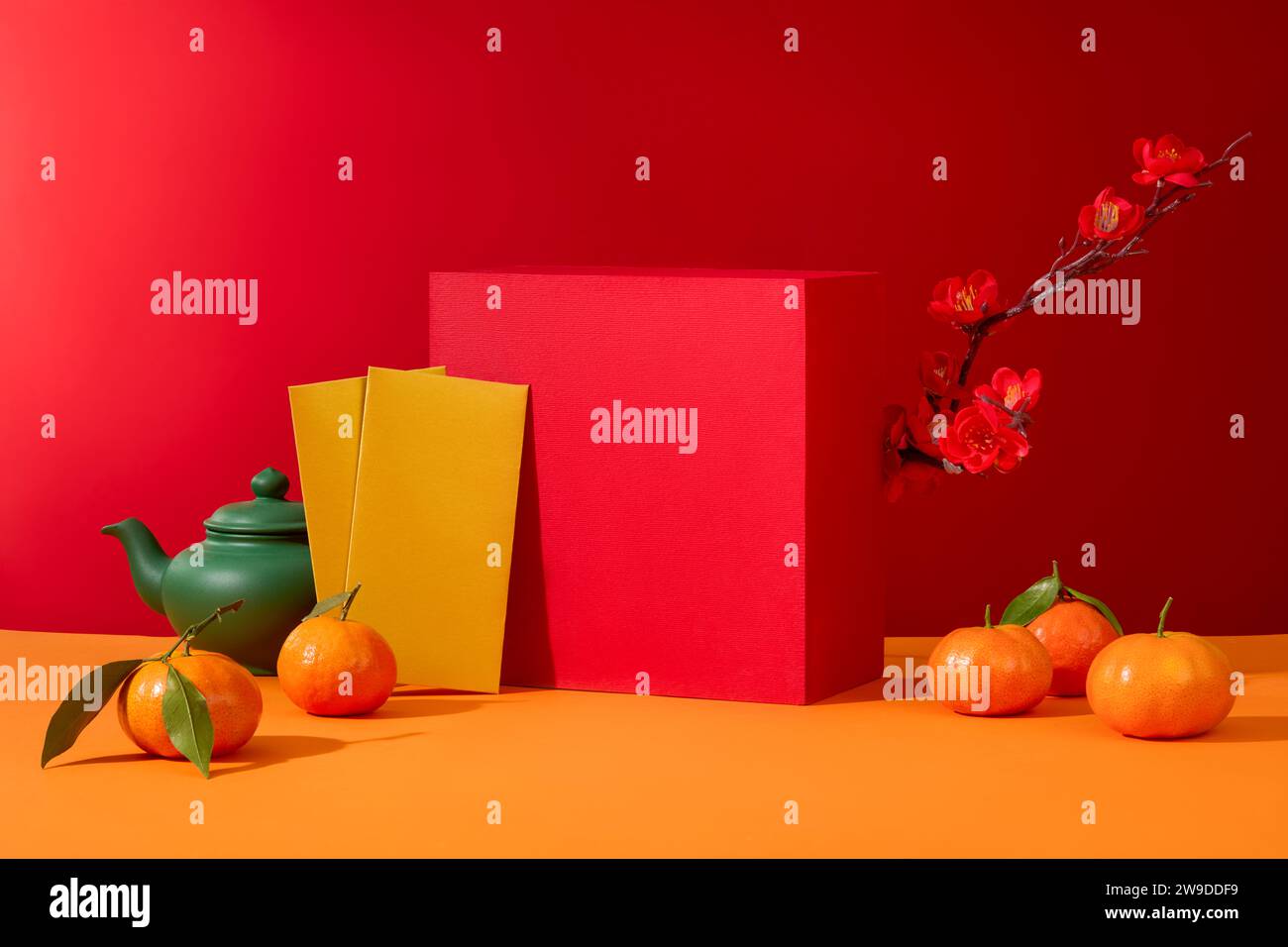 A large red cube decorated with yellow envelopes and some tangerines ...