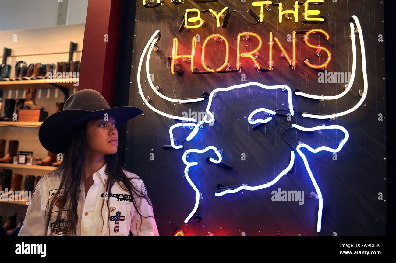 Bull rider Najiah Knight looks at neon lights showing a bull in an ...
