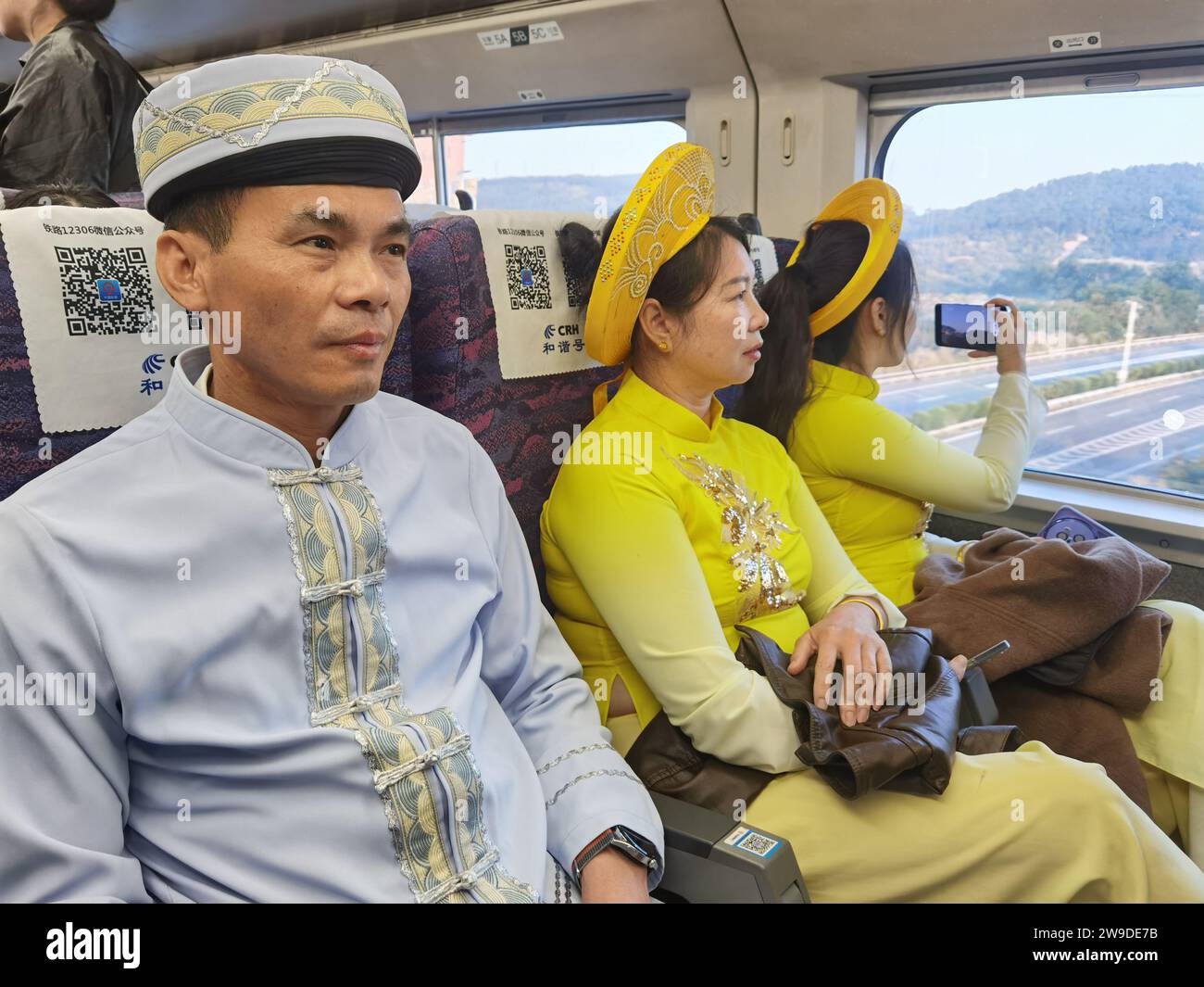 Dongxing. 27th Dec, 2023. Passengers in traditional costumes are seen ...