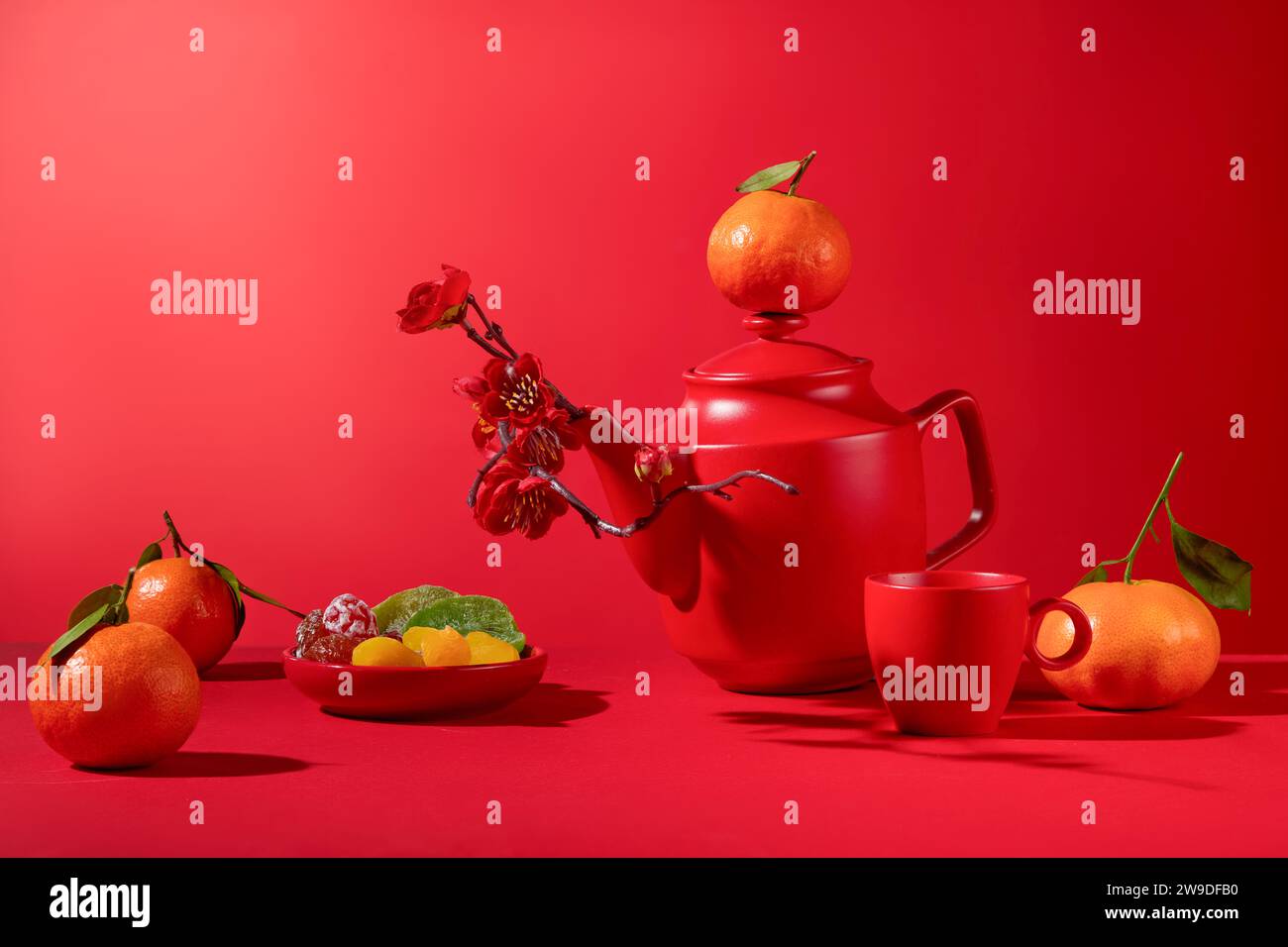 Red tea set arranged with a dish of colorful candy fruits. Red ...