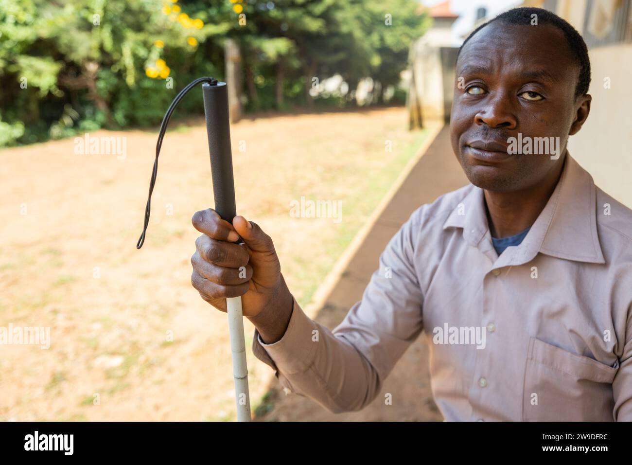 A blind man after a long walk in the brooding sun rests sitting in the ...