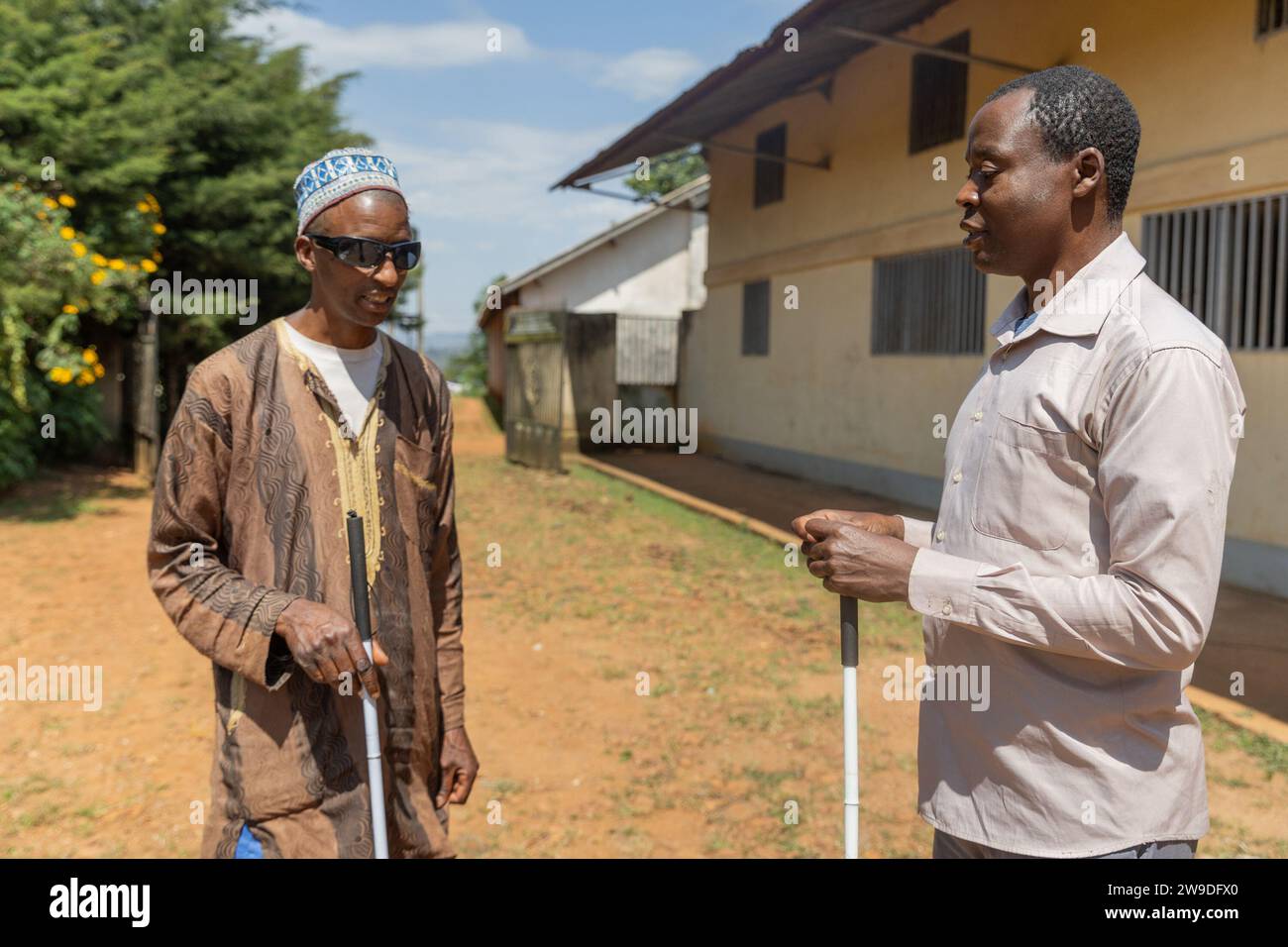 Two sightless people with their white canes stop and converse in the ...
