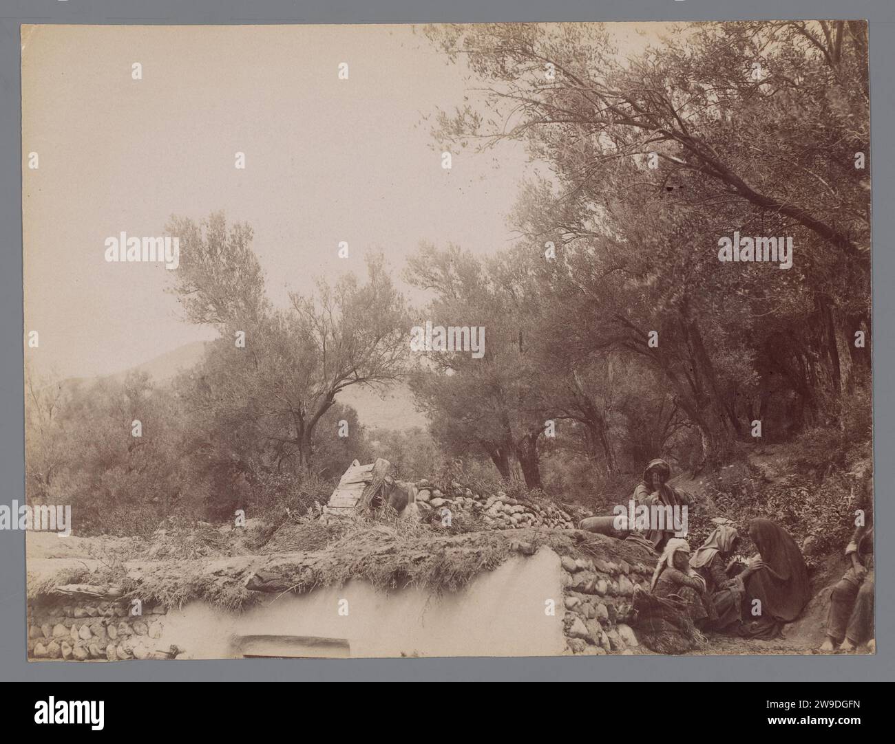 Group of men resting on the floor, along a roof edge of a white house ...
