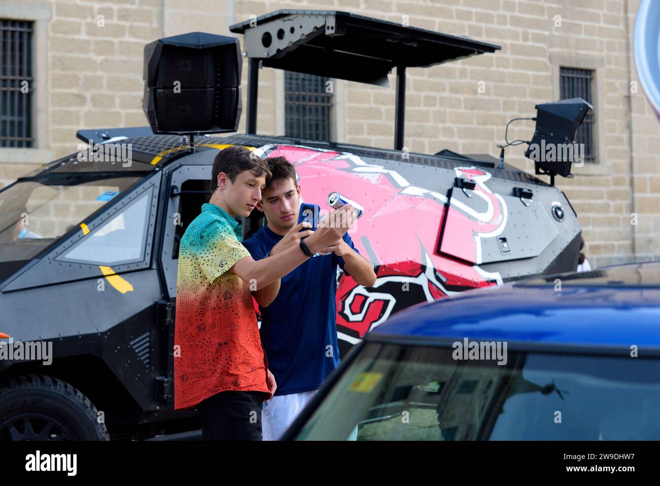 Two boys taking a picture of a Red Bull can in San Lorenzo de El ...