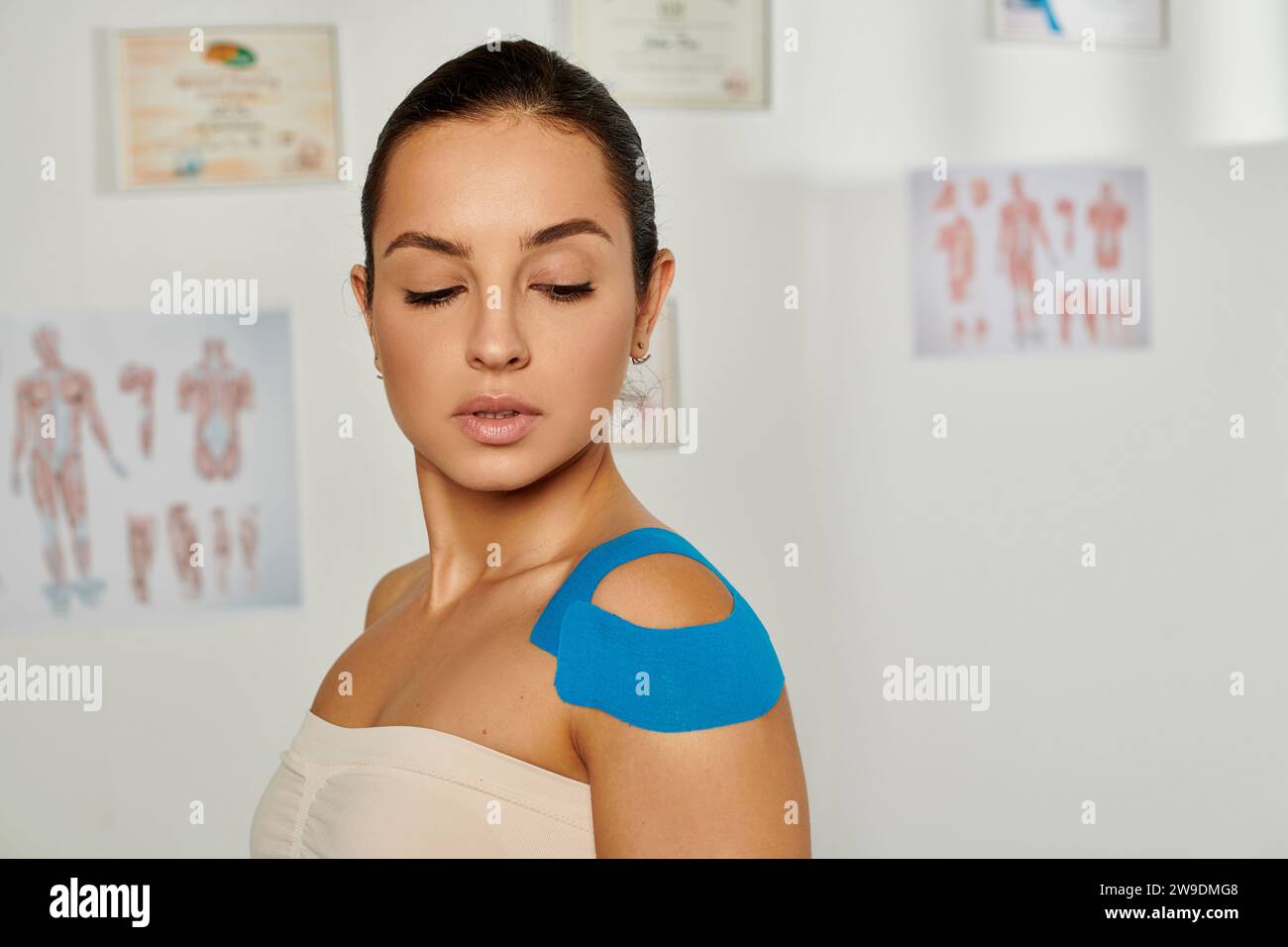 attractive female patient with kinesiological tapes on her body in ...