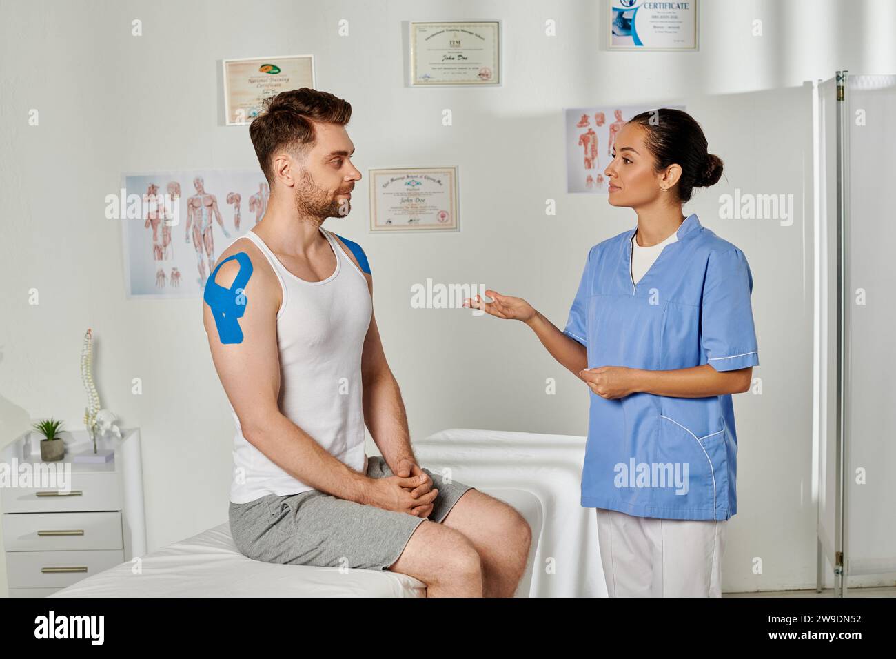 good looking bearded patient and attractive young doctor looking at ...