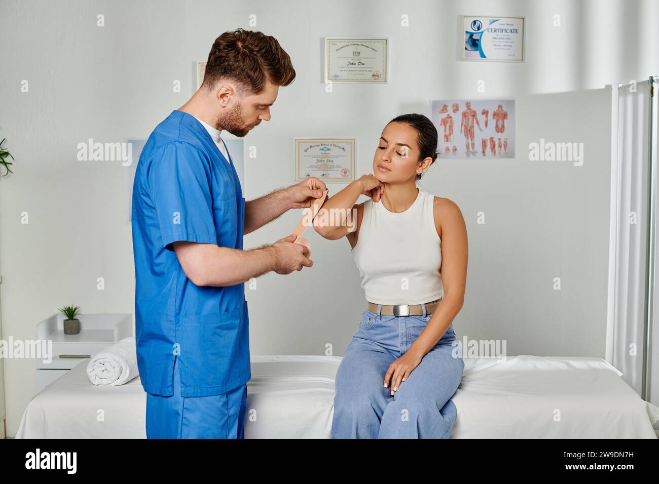 handsome bearded doctor putting kinesiological tape on elbow of his ...