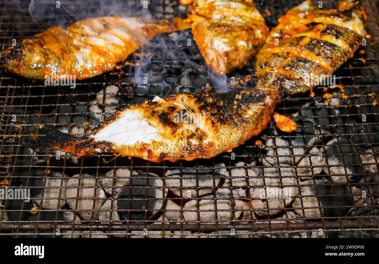 Delicious Asian fish fry served on a BBQ table. Grilled fish laid on ...