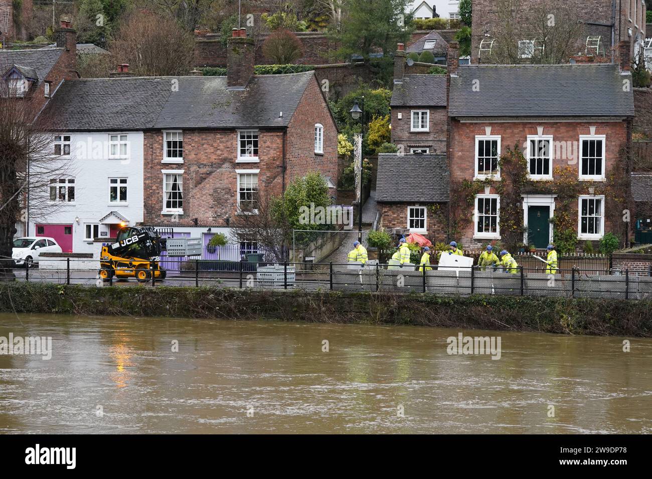The swollen River Severn as flood defences are put in place along the ...