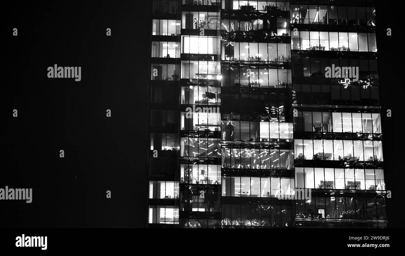 Pattern of office buildings windows illuminated at night. Glass ...