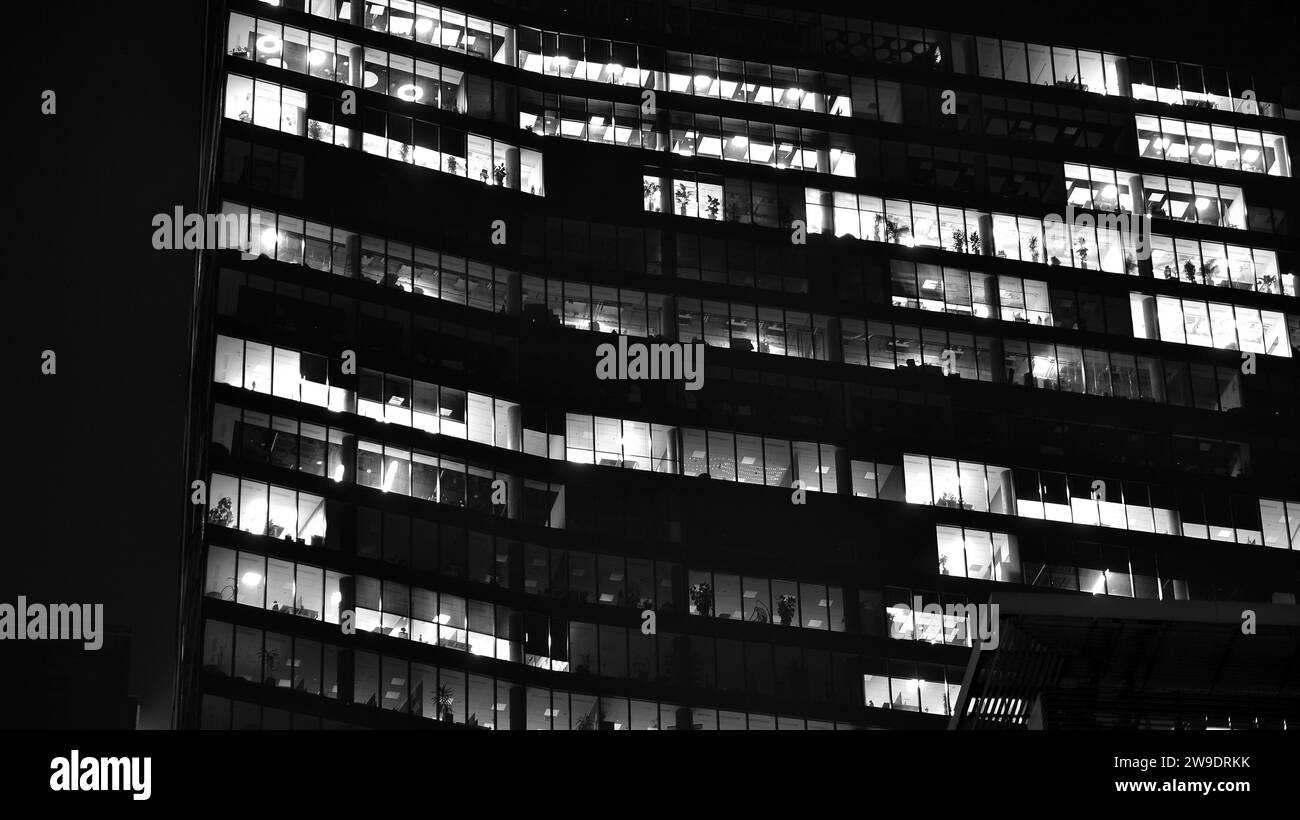 Pattern of office buildings windows illuminated at night. Glass ...