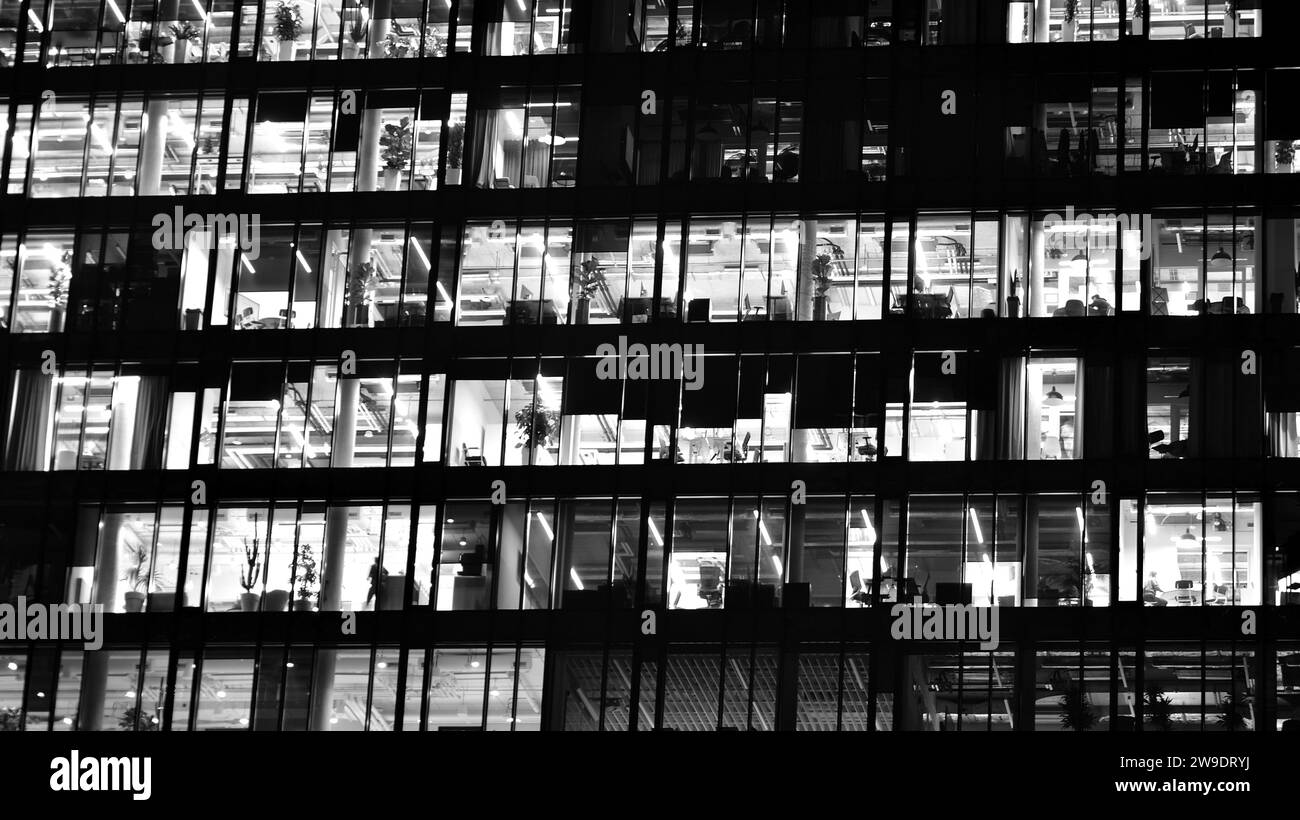 Pattern of office buildings windows illuminated at night. Glass ...