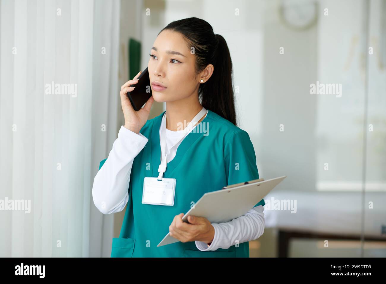 Portrait of rehabilitation center nurse answering phone call from ...